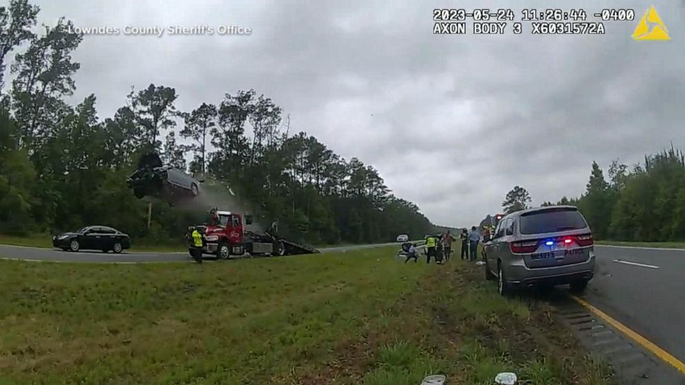 Police cam shows moment car flips over tow truck on highway | GMA