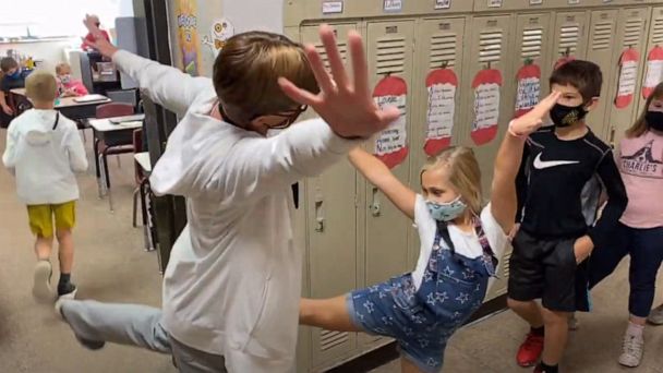 Teacher does special socially distanced greeting with each student to ...