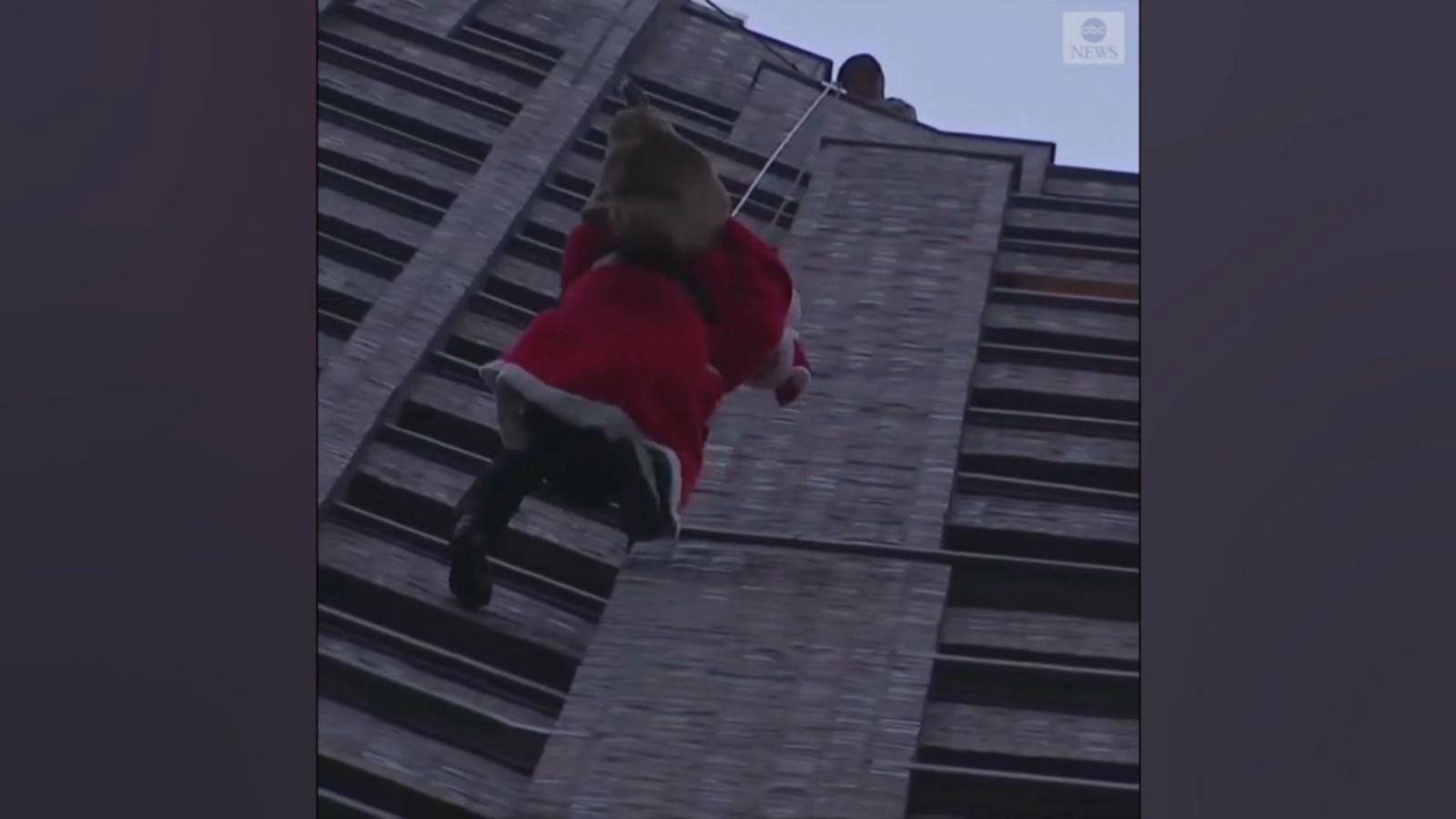 Santa Claus rappels down building to deliver gifts - Good Morning America